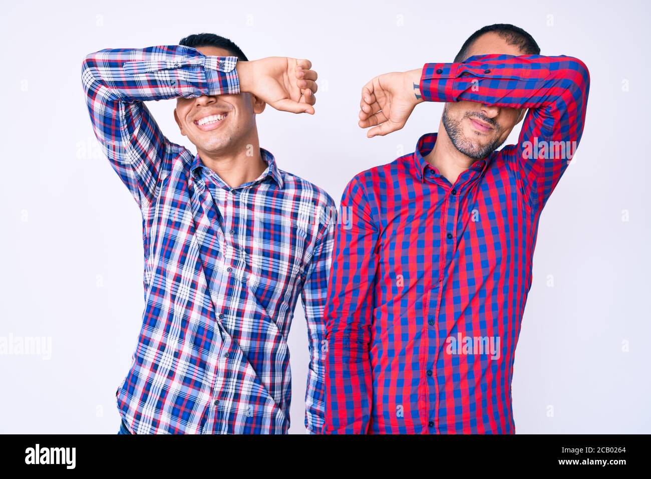 Young gay couple of two men wearing casual clothes covering eyes with ...