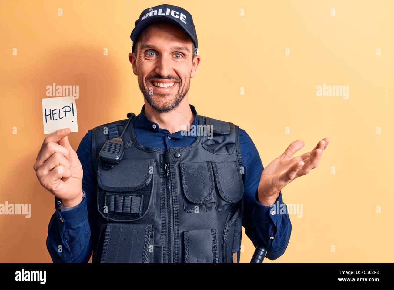 Handsome policeman wearing uniform and bulletprof holding reminder with ...