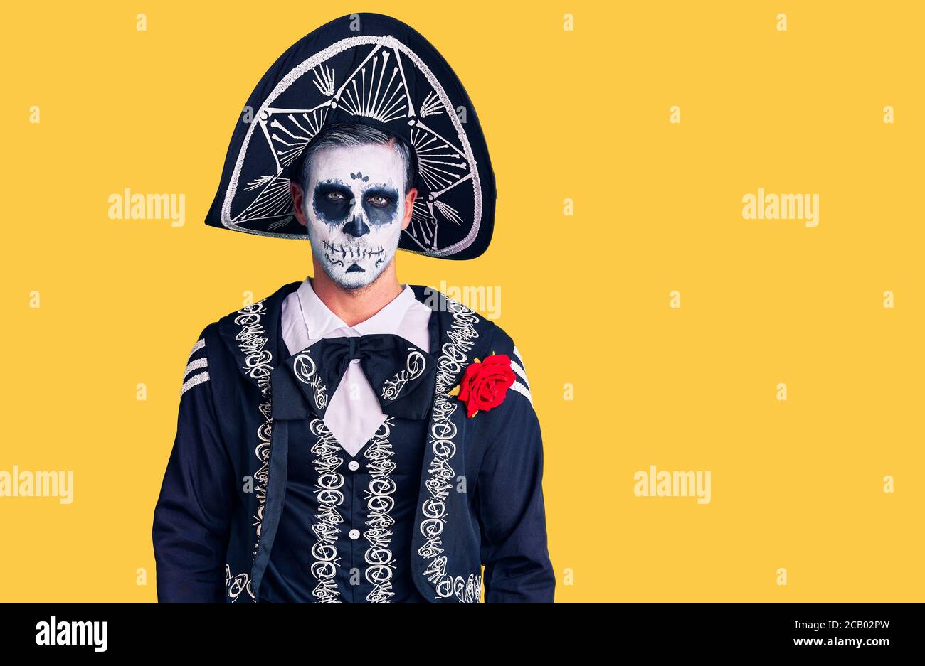 Young man wearing day of the dead costume over background depressed and ...