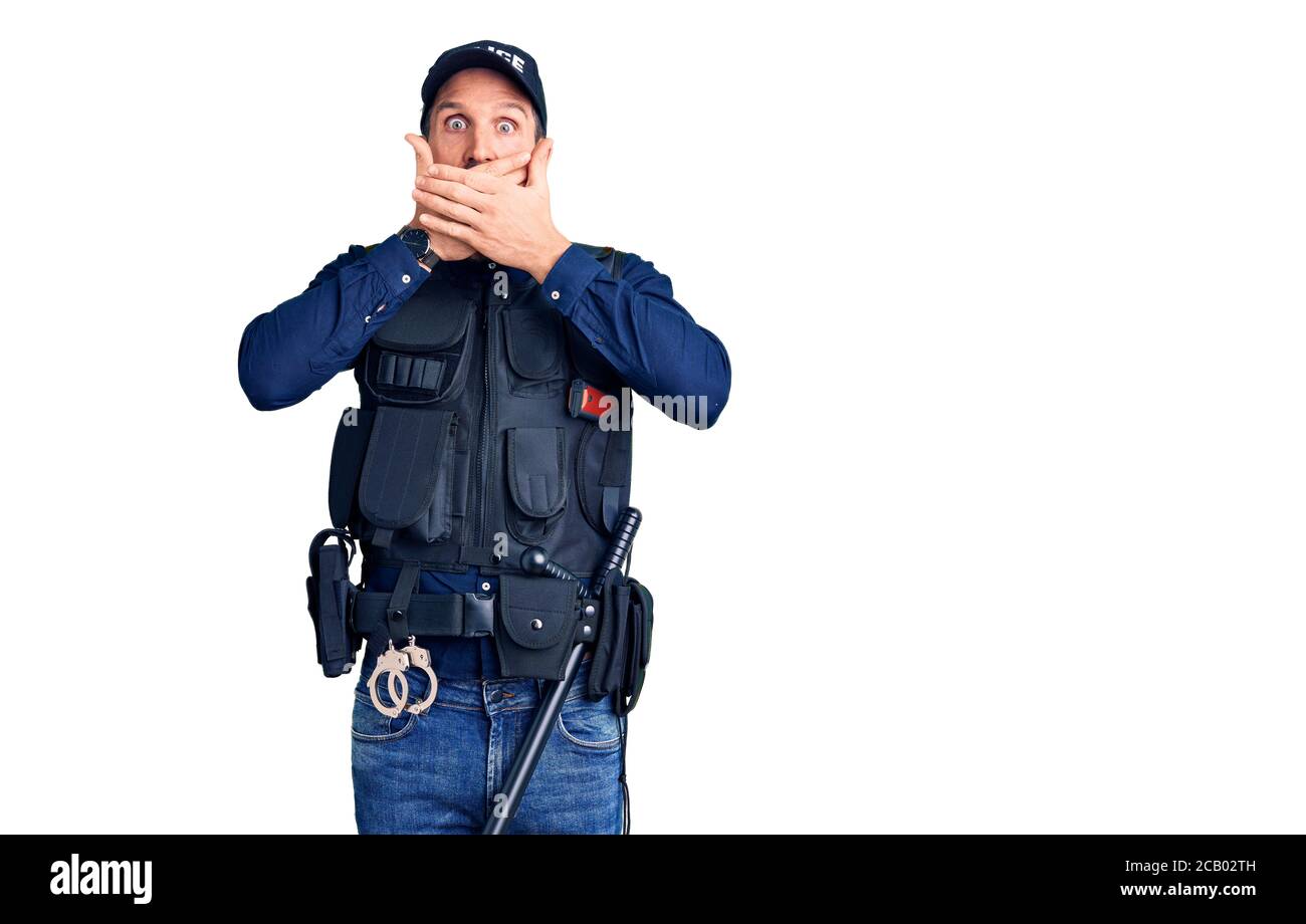 Young handsome man wearing police uniform shocked covering mouth with ...