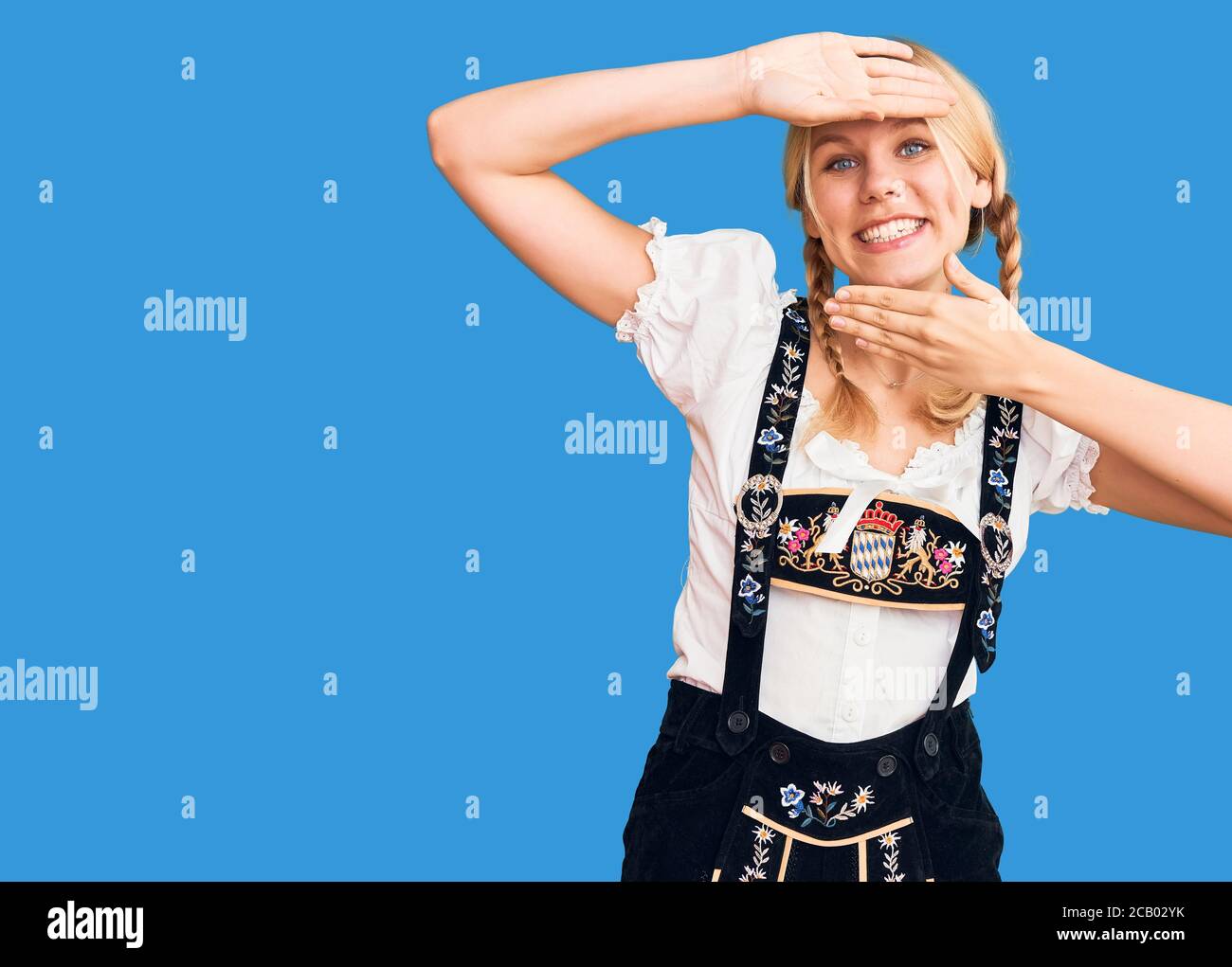 Young beautiful blonde woman wearing oktoberfest dress smiling cheerful ...