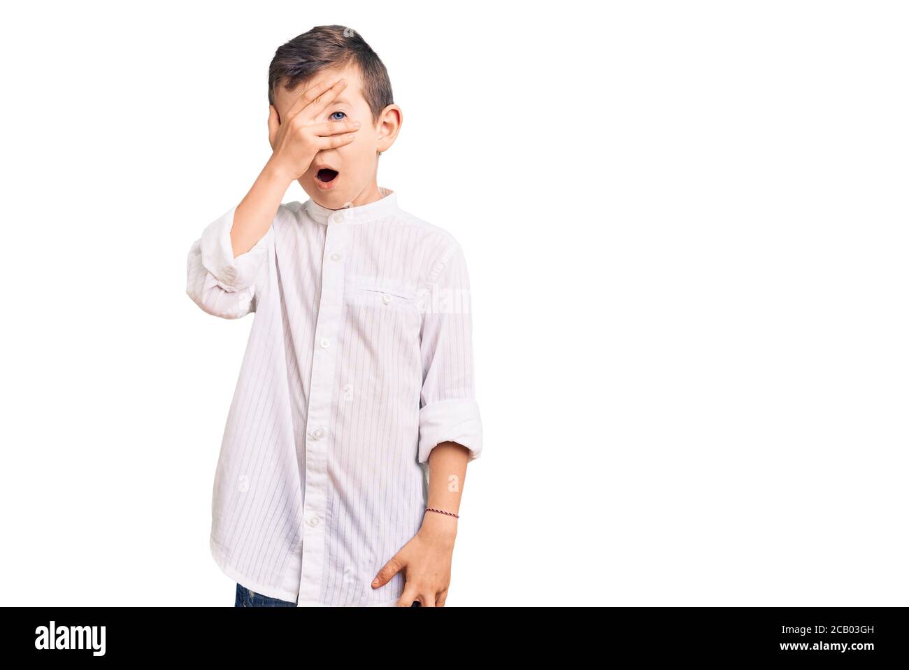 Cute blond kid wearing elegant shirt peeking in shock covering face and ...