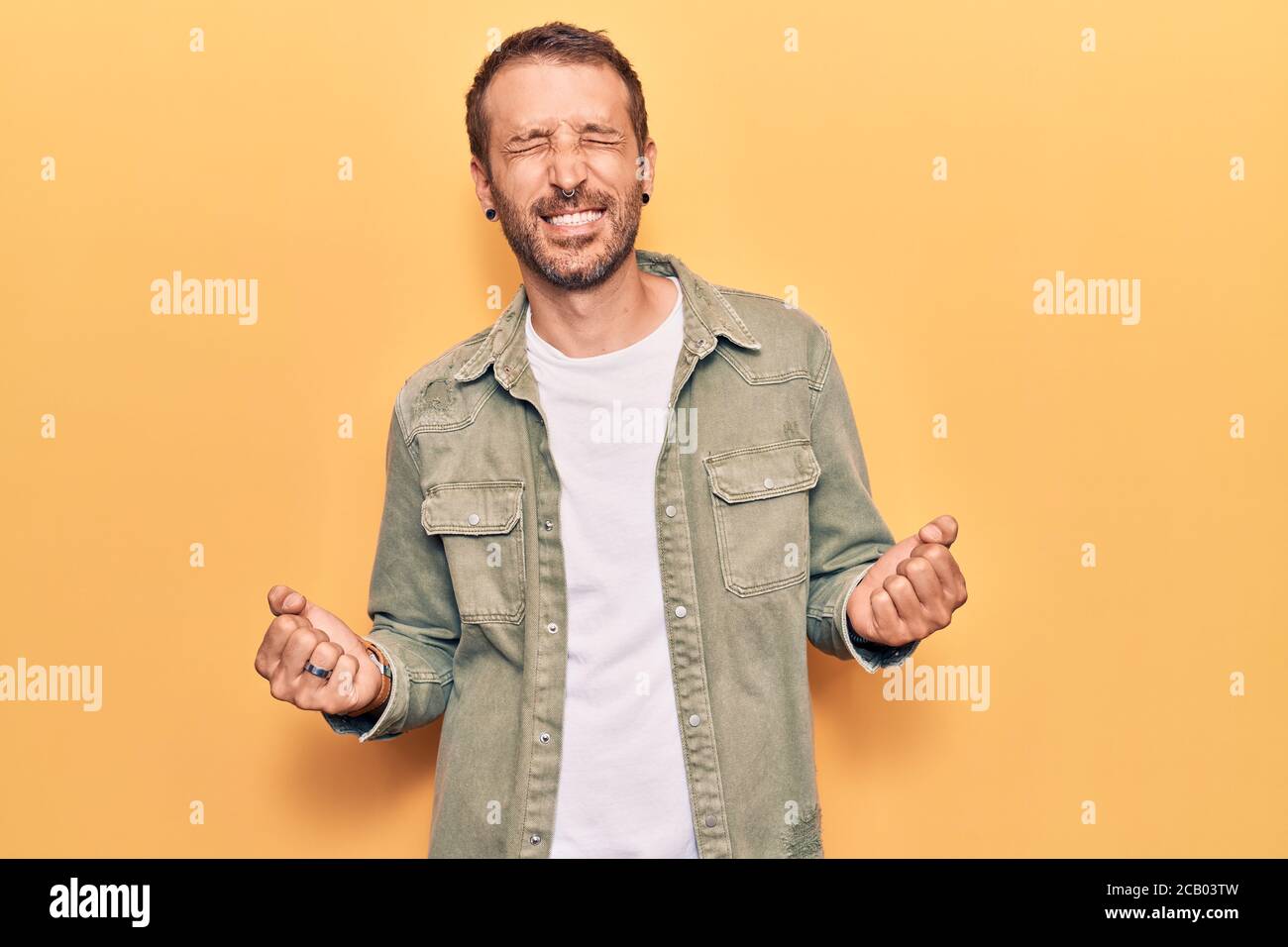 Young handsome man wearing casual clothes very happy and excited doing ...
