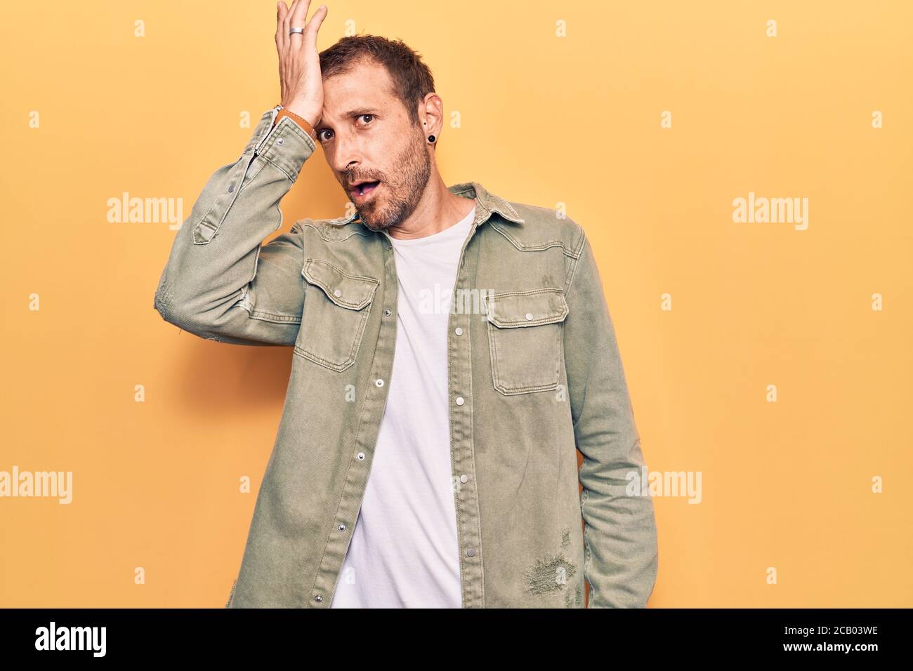 Young handsome man wearing casual clothes surprised with hand on head ...