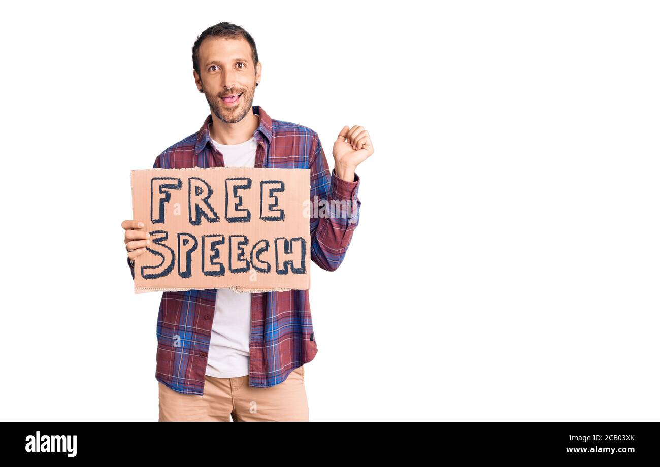 Young handsome man holding free speech banner screaming proud ...