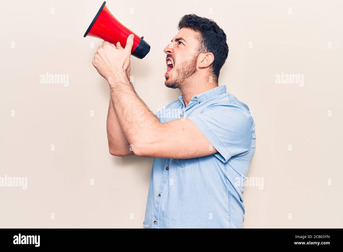 Young handsome hispanic man with angry expression. Screaming loud using ...
