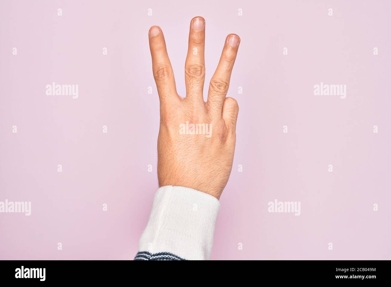 Hand of caucasian young man showing fingers over isolated pink ...