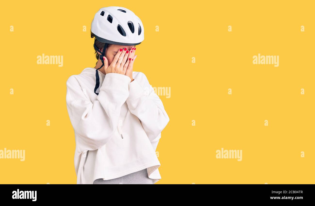 Beautiful brunette young woman wearing bike helmet and sporty clothes ...