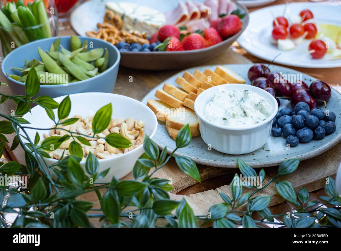 Party Table with Dips Nuts Cracker Fruits Stock Photo - Alamy