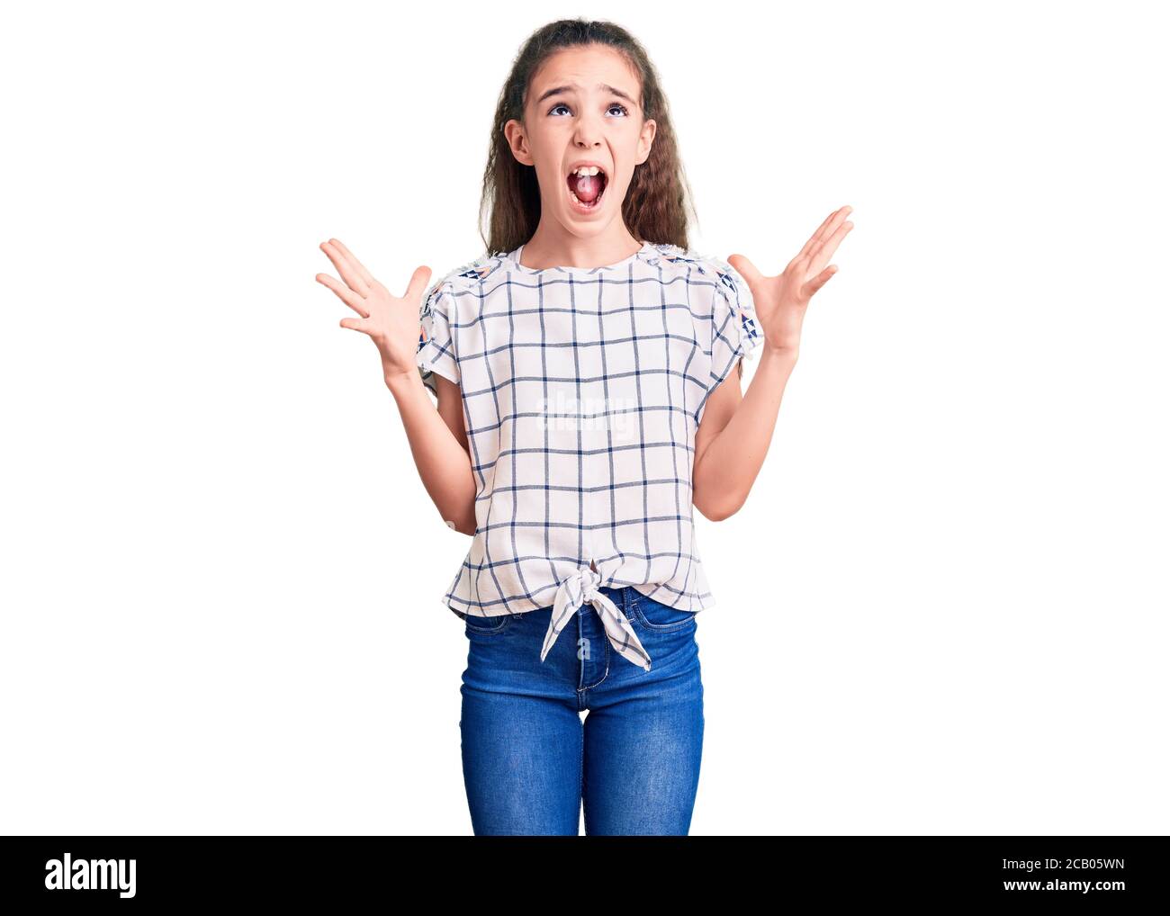 Cute hispanic child girl wearing casual clothes crazy and mad shouting ...