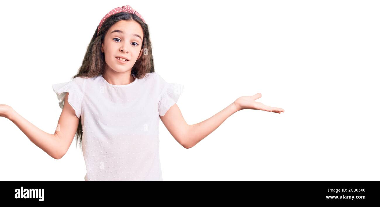 Cute hispanic child girl wearing casual white tshirt clueless and ...