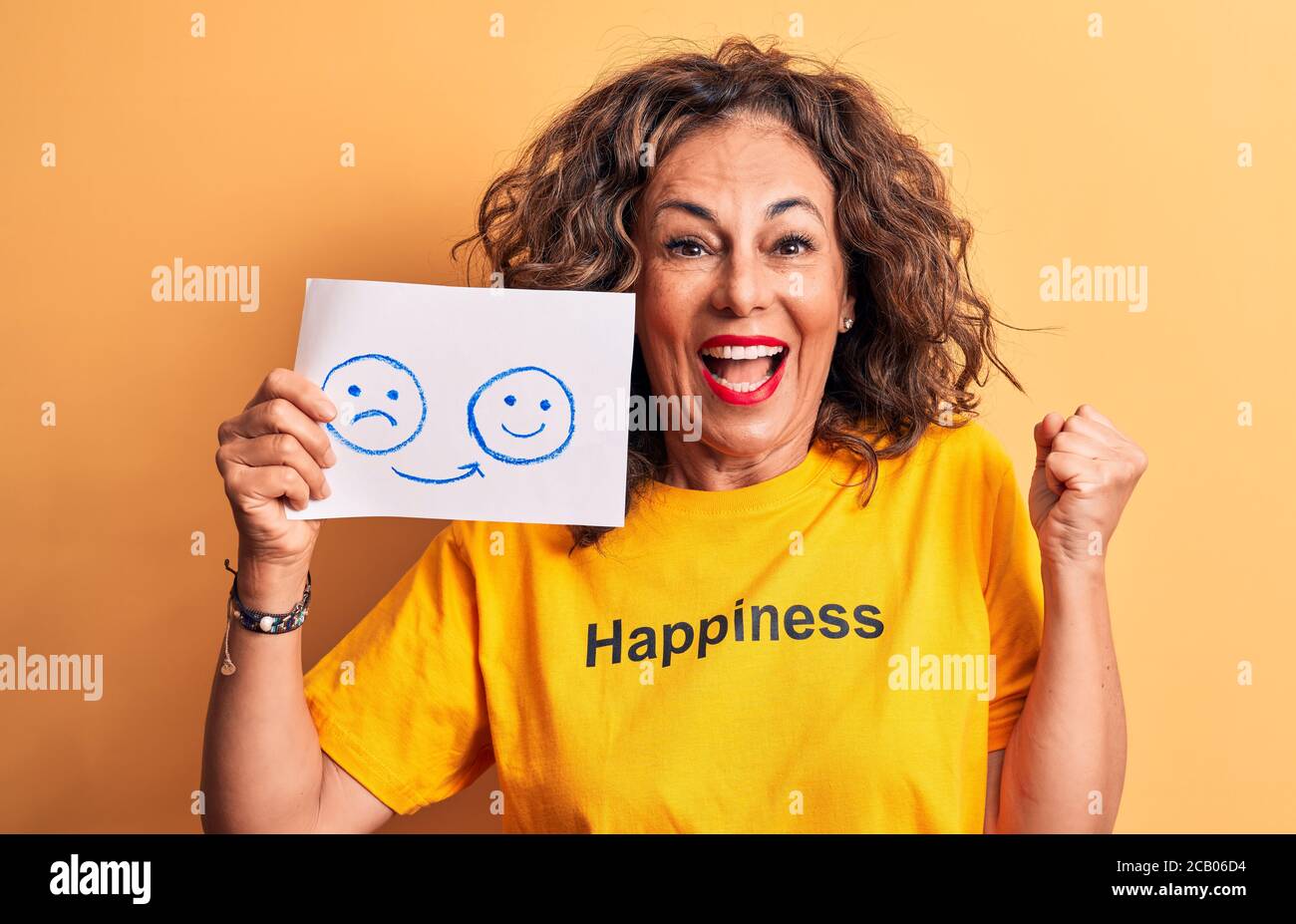 Middle age woman wearing t-shirt with happiness word holding sad to ...