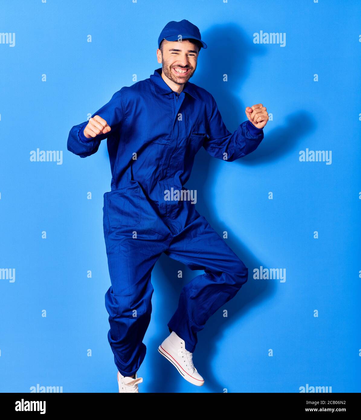 Young handsome hispanic man wearing painter uniform and cap smiling ...