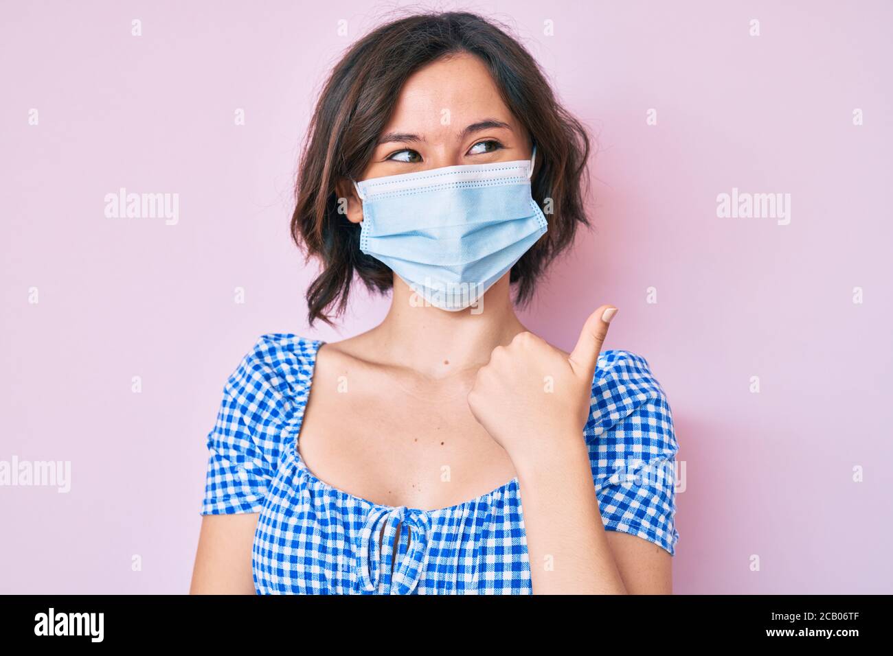 Young beautiful woman wearing medical mask smiling with happy face ...
