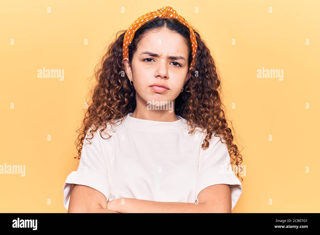 Beautiful kid girl with curly hair wearing casual clothes skeptic and ...