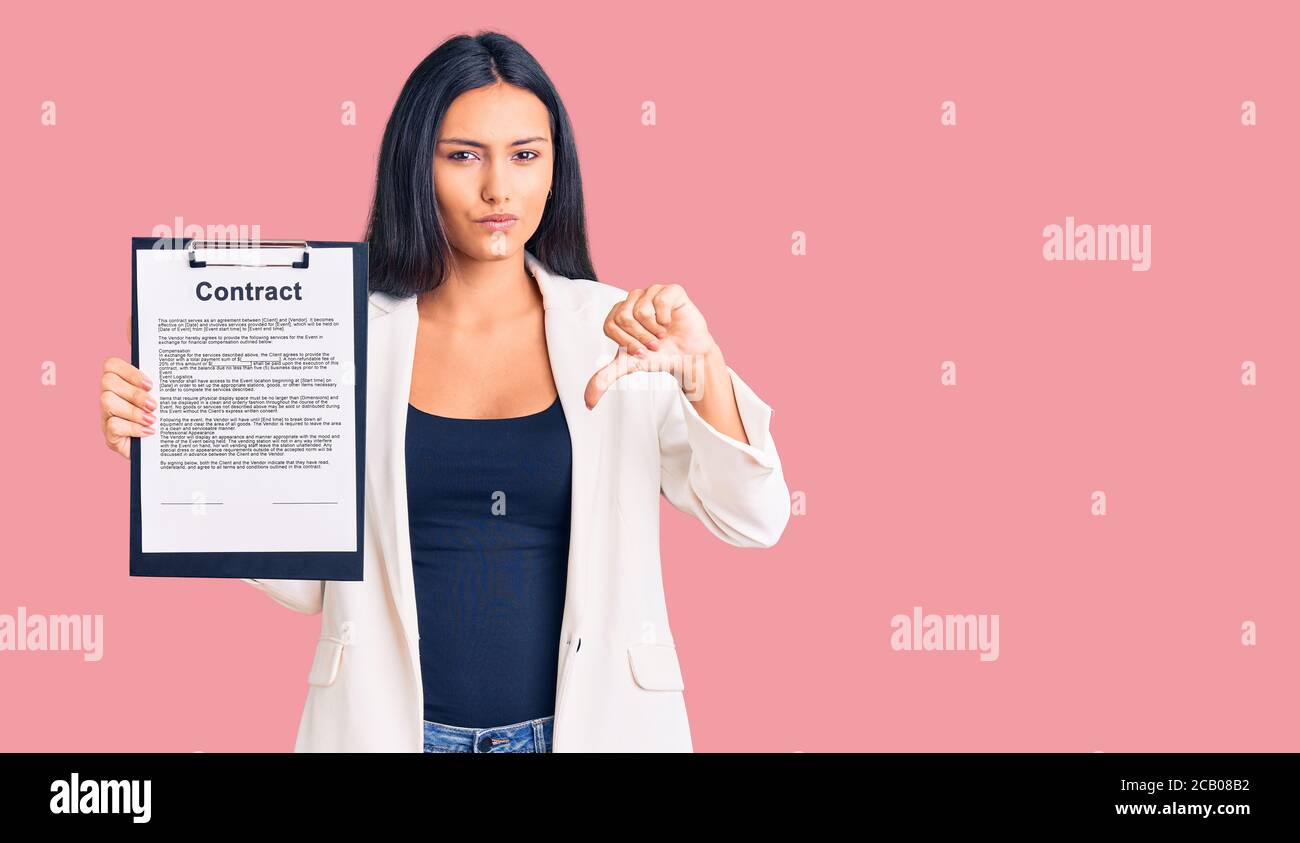 Young beautiful latin girl holding clipboard with contract document ...