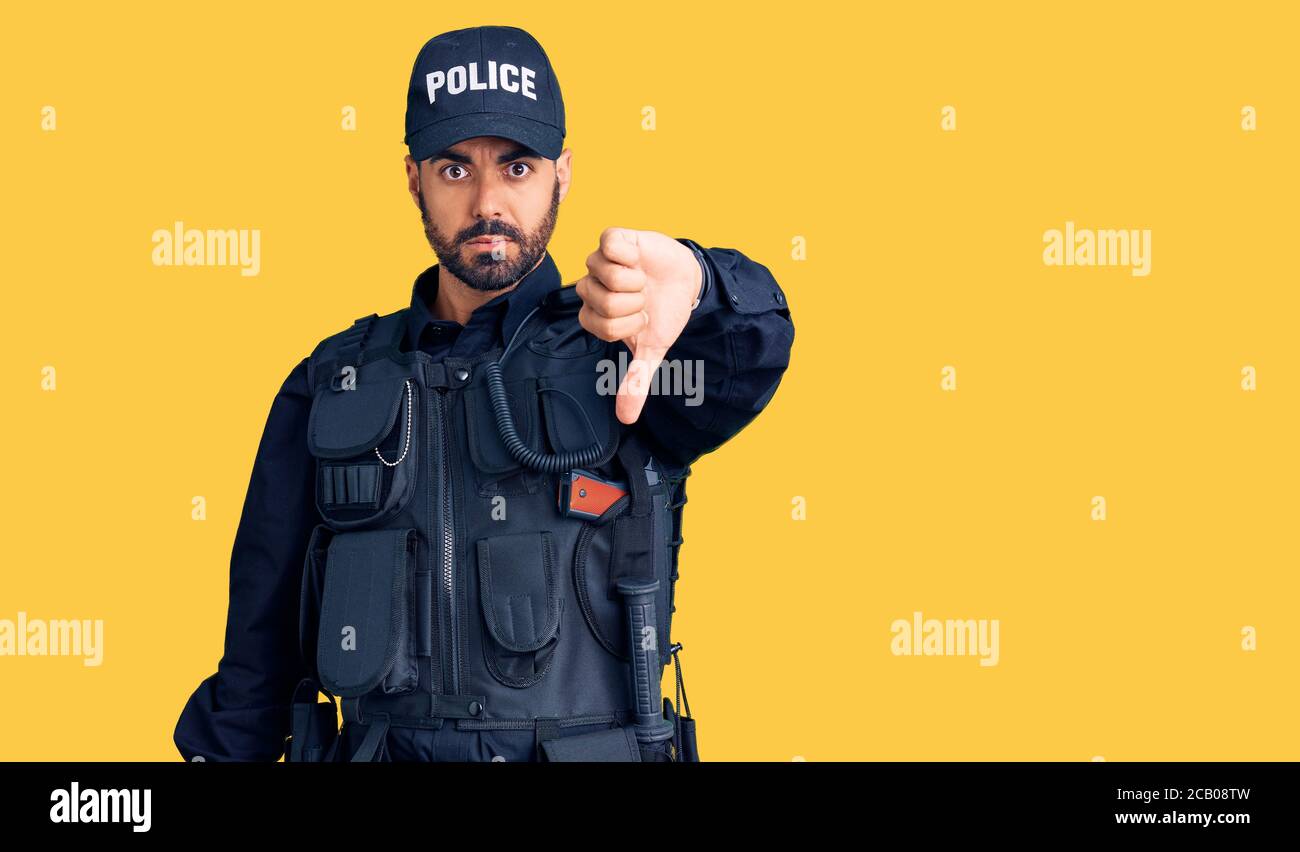 Young hispanic man wearing police uniform looking unhappy and angry ...