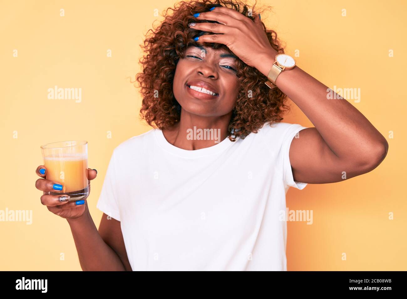 Young african american woman drinking glass of orange juice stressed ...