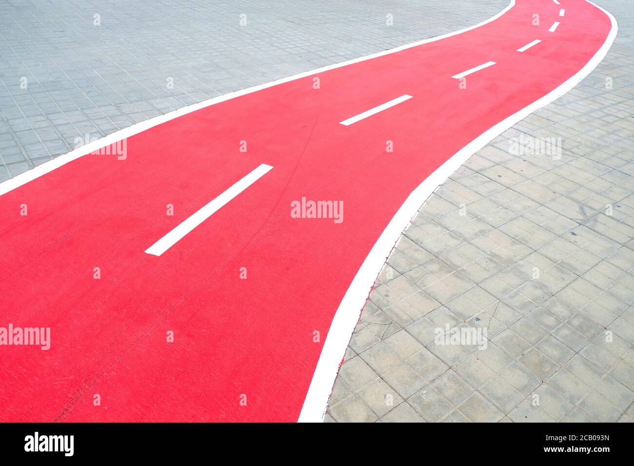 A red biking path in the city winding in perspective view. Two biking ...