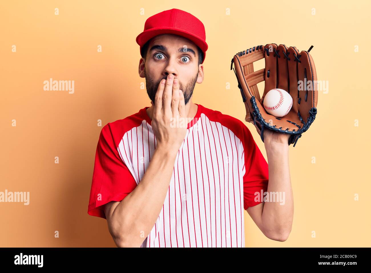 Young handsome man with beard playing baseball using ball and glove ...