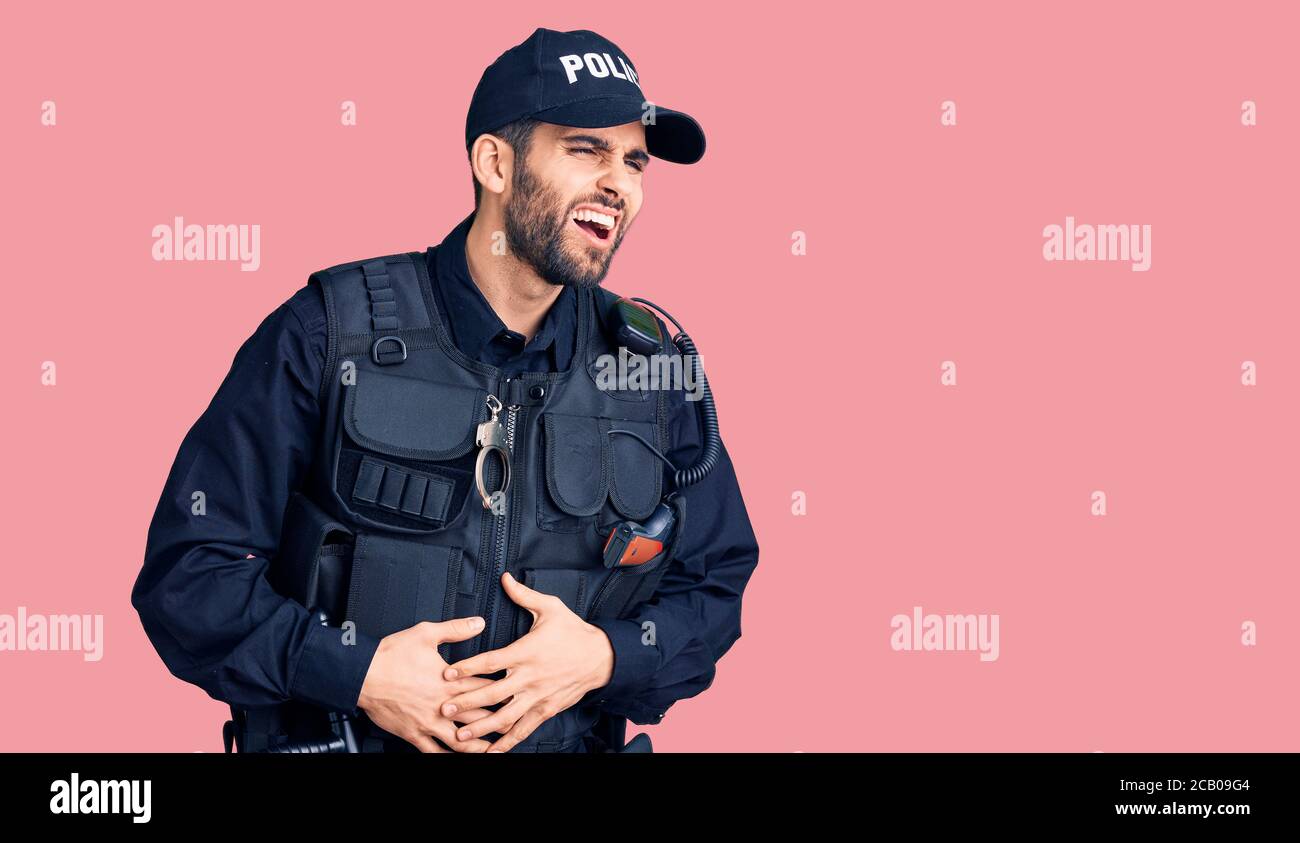 Young handsome man with beard wearing police uniform with hand on ...