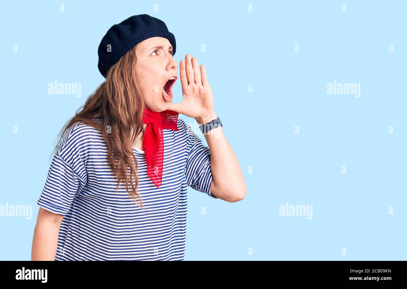 Young beautiful blonde woman wearing french beret and striped t-shirt ...