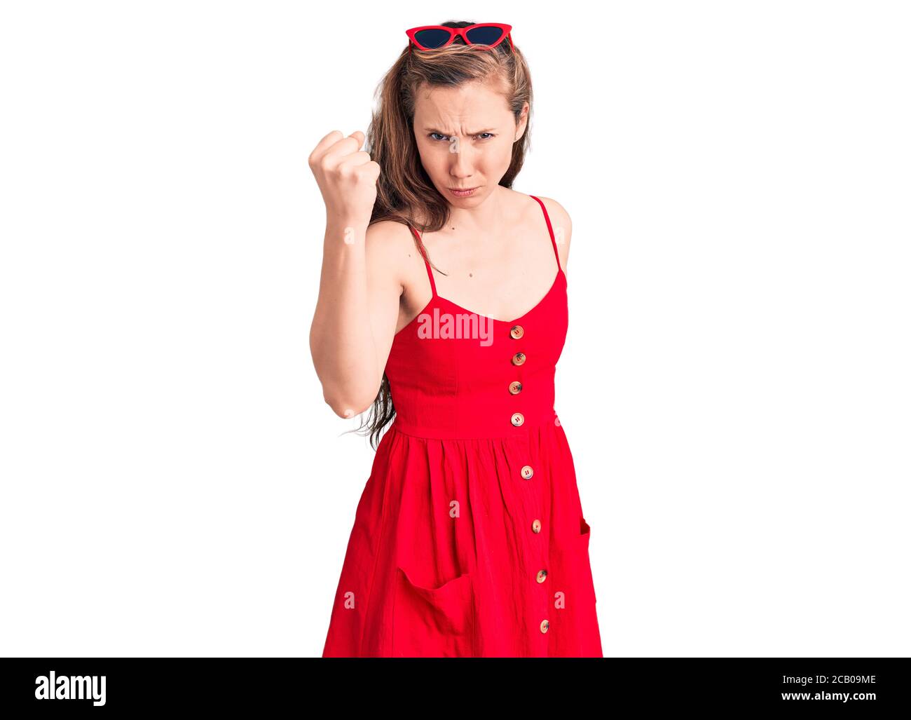 Young beautiful blonde woman wearing casual dress angry and mad raising ...