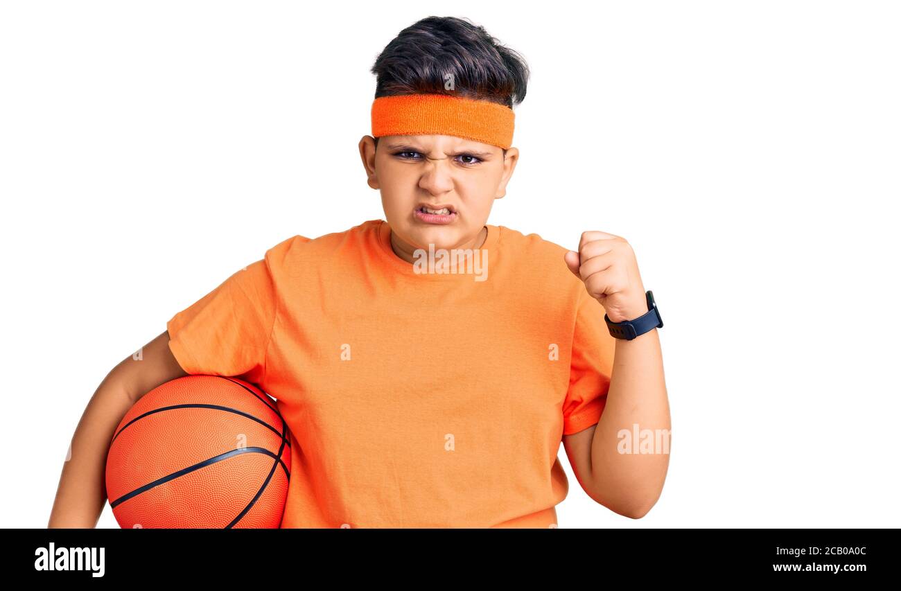 Little boy kid holding basketball ball annoyed and frustrated shouting ...