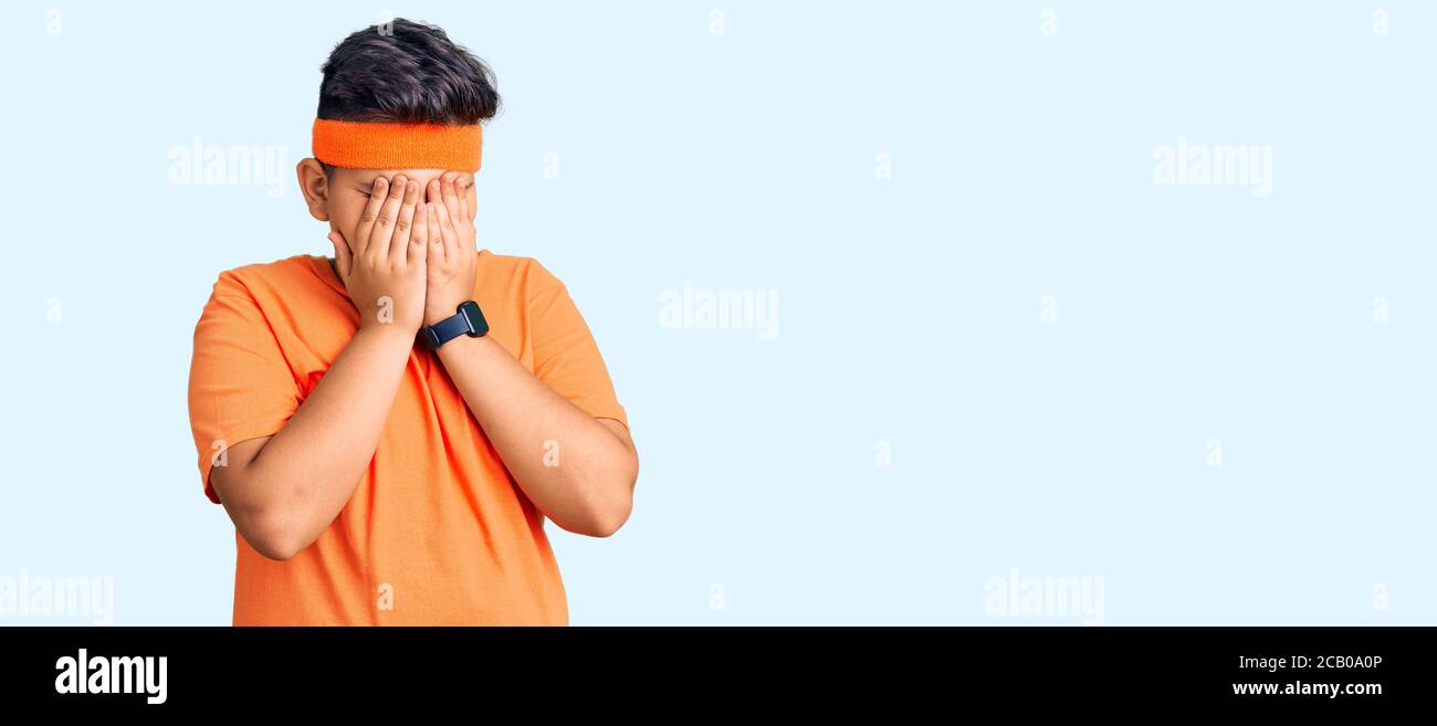 Little boy kid wearing sportswear with sad expression covering face ...