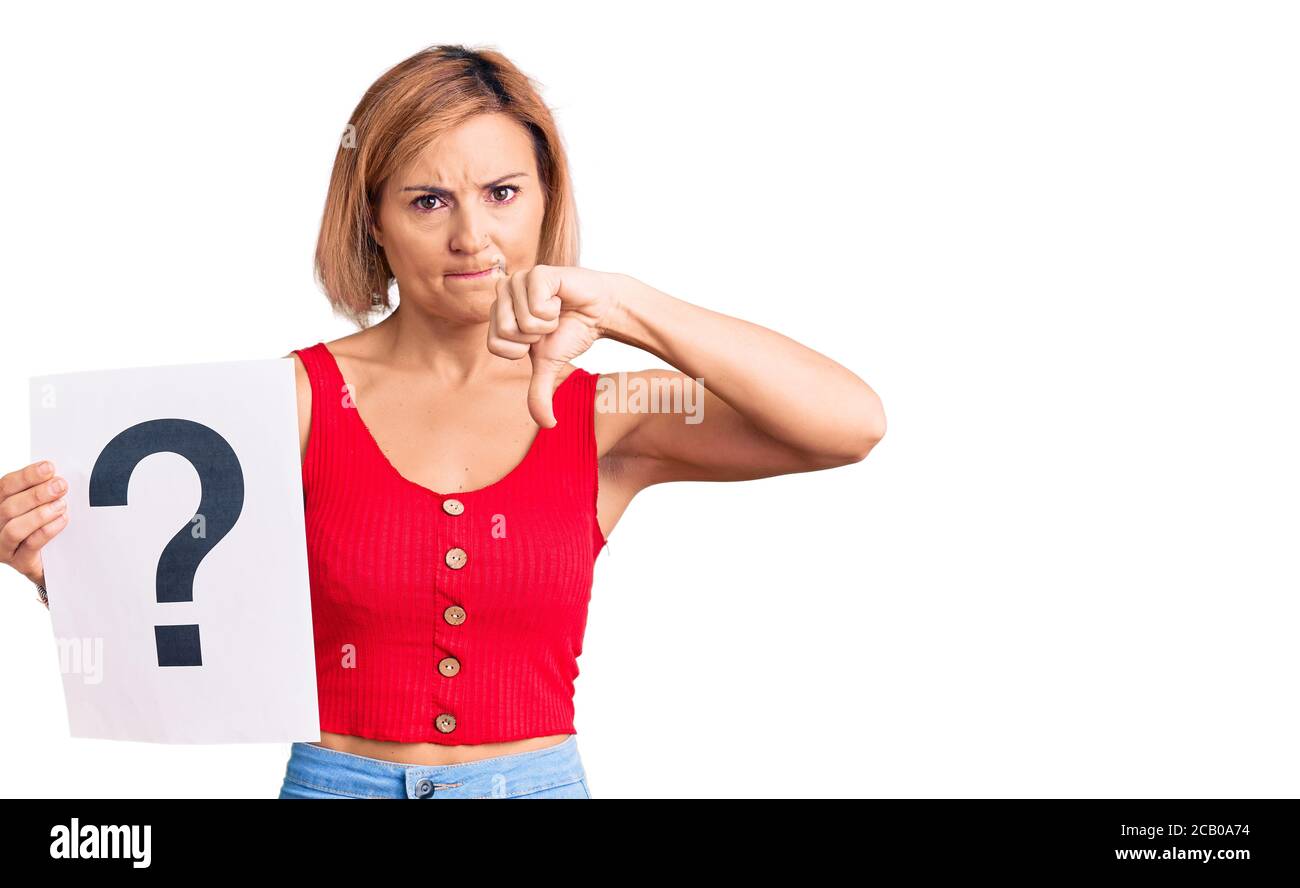 Young blonde woman holding question mark with angry face, negative sign ...