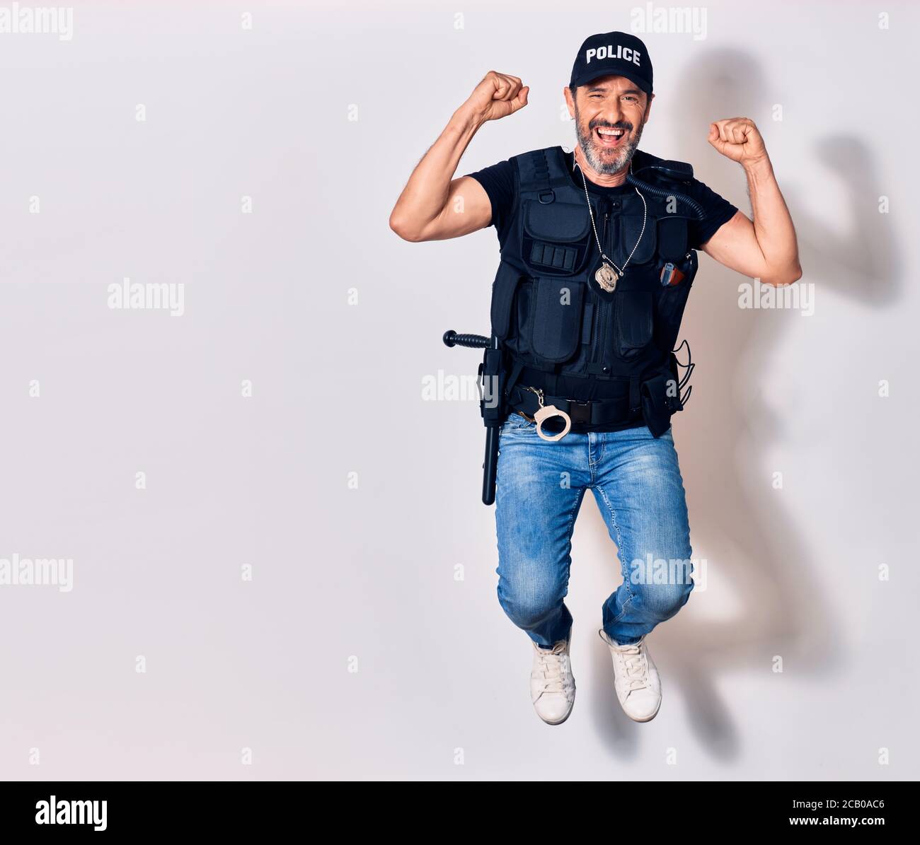 Middle age handsome man wearing police unifrom smiling happy. Jumping ...