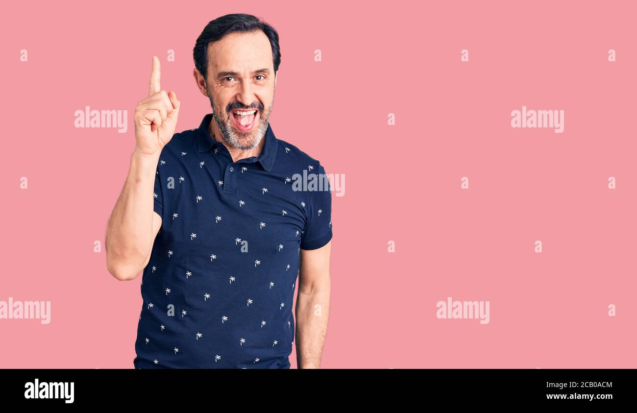 Middle age handsome man wearing casual polo pointing finger up with ...