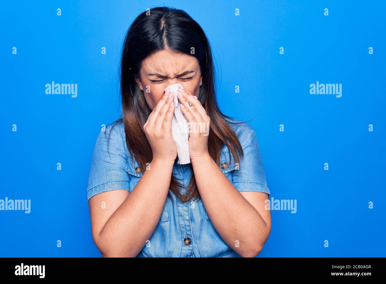 Young beautiful woman sick for flu. Using paper handkerchief on full ...