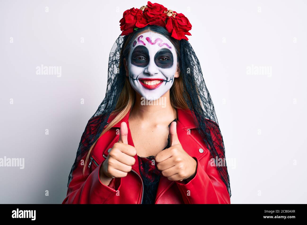 Woman wearing day of the dead costume with thumbs up doing ok sign ...