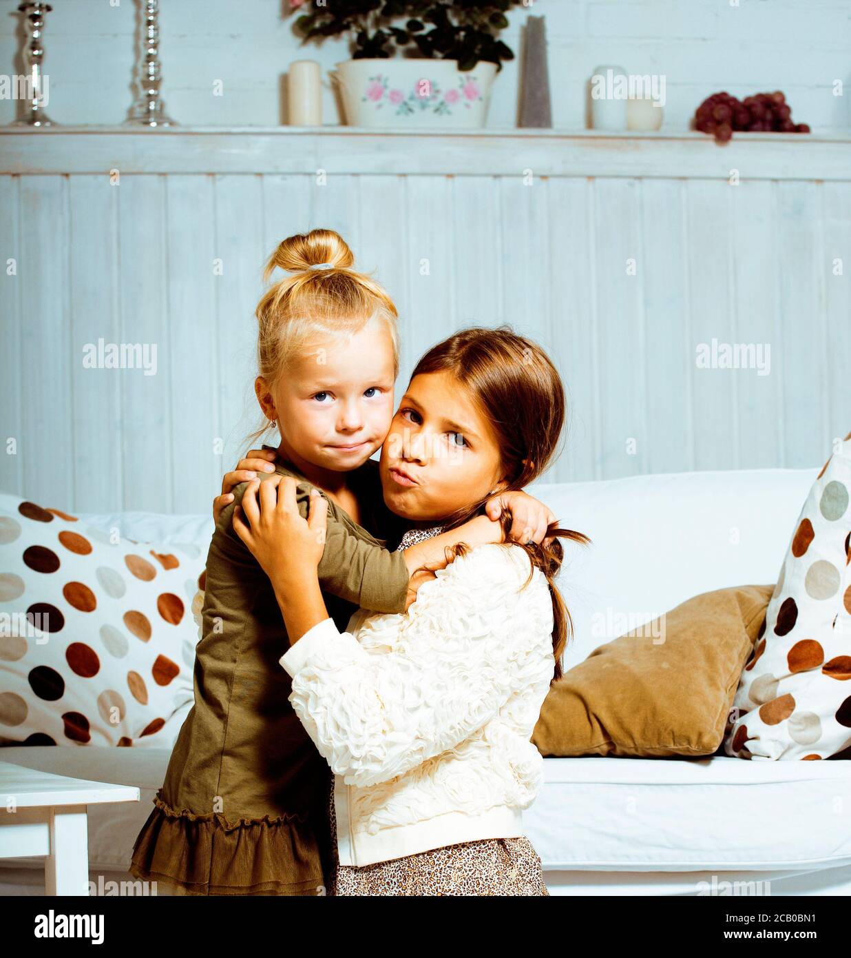 two cute sisters at home playing, little girl in house interior ...