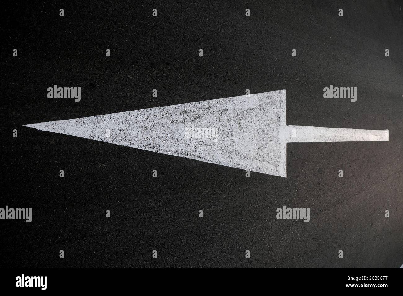 Long white arrow pointing left on black background, angled perspective ...