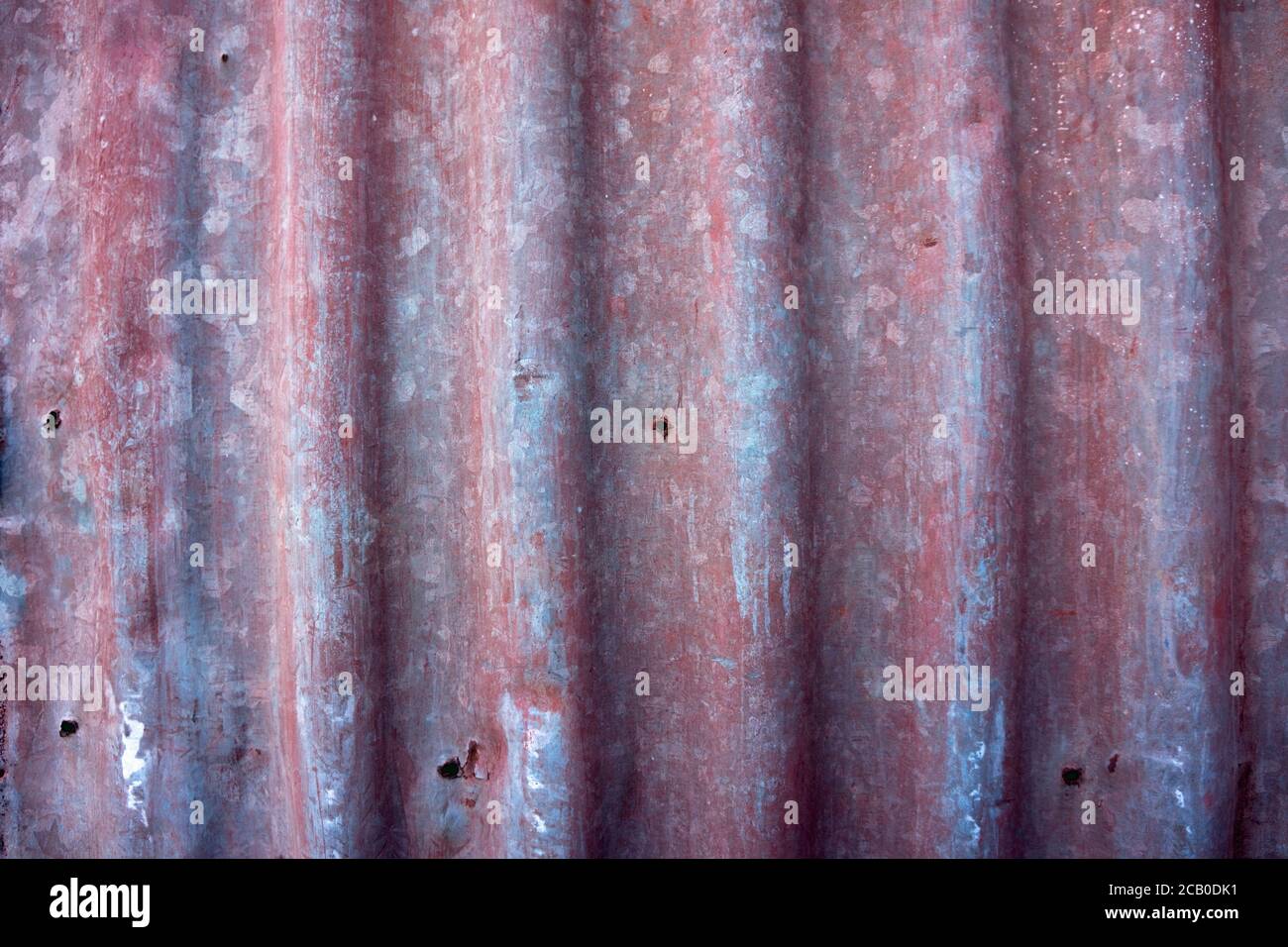 Abstract red texture background on a tin metal sheet with a flow of ...
