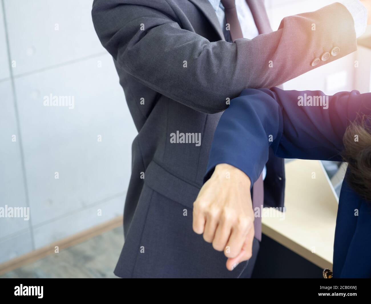 Elbow bump. Businessman and business woman use elbow to bump into ...
