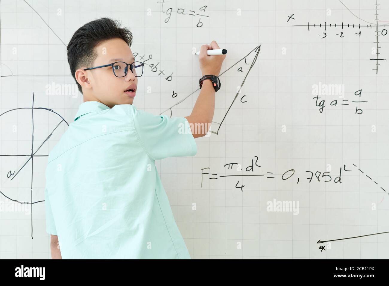 Vietnamese schoolboy listening to advice of classmate when solving ...