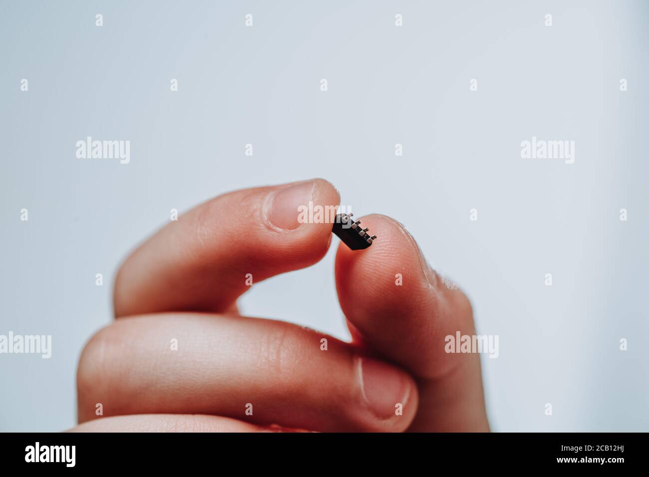 A small black chip holds a children's hand. Chipization of people after ...