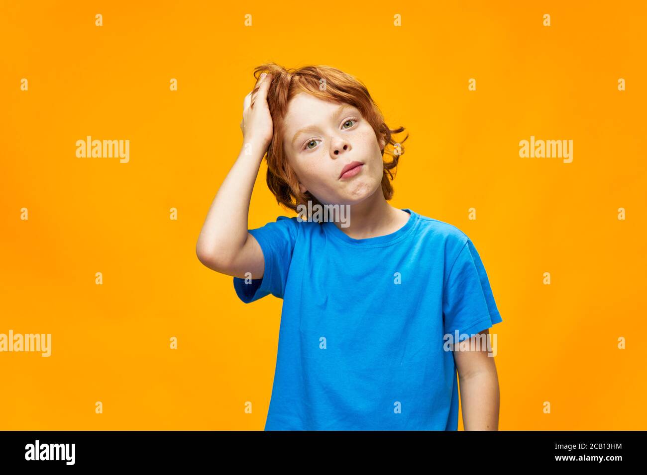 boy red hair blue t-shirt yellow isolated background freckles and ...