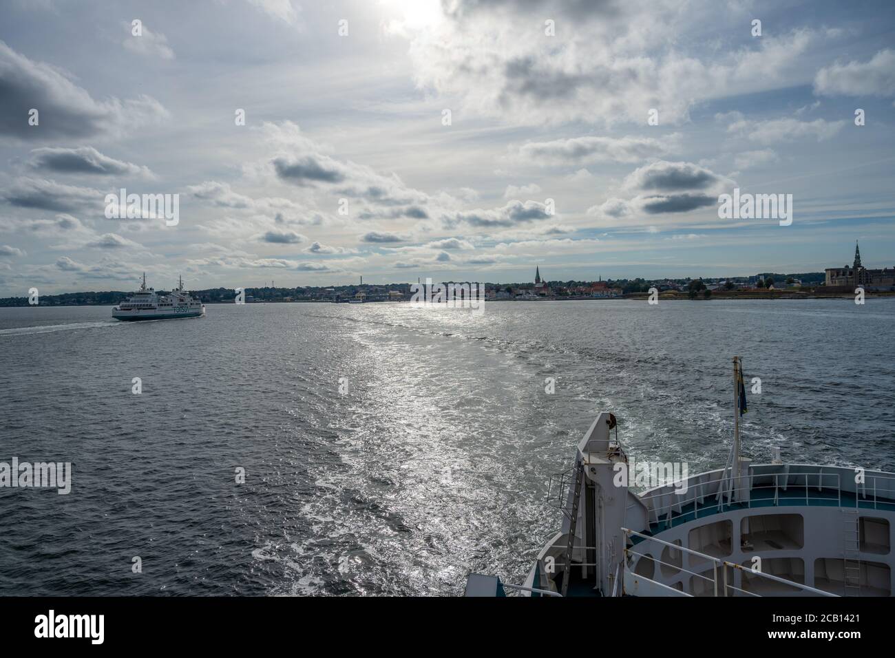 Oceanview towards Elsinore in Denmark from the aft of a boat. A backlit ...