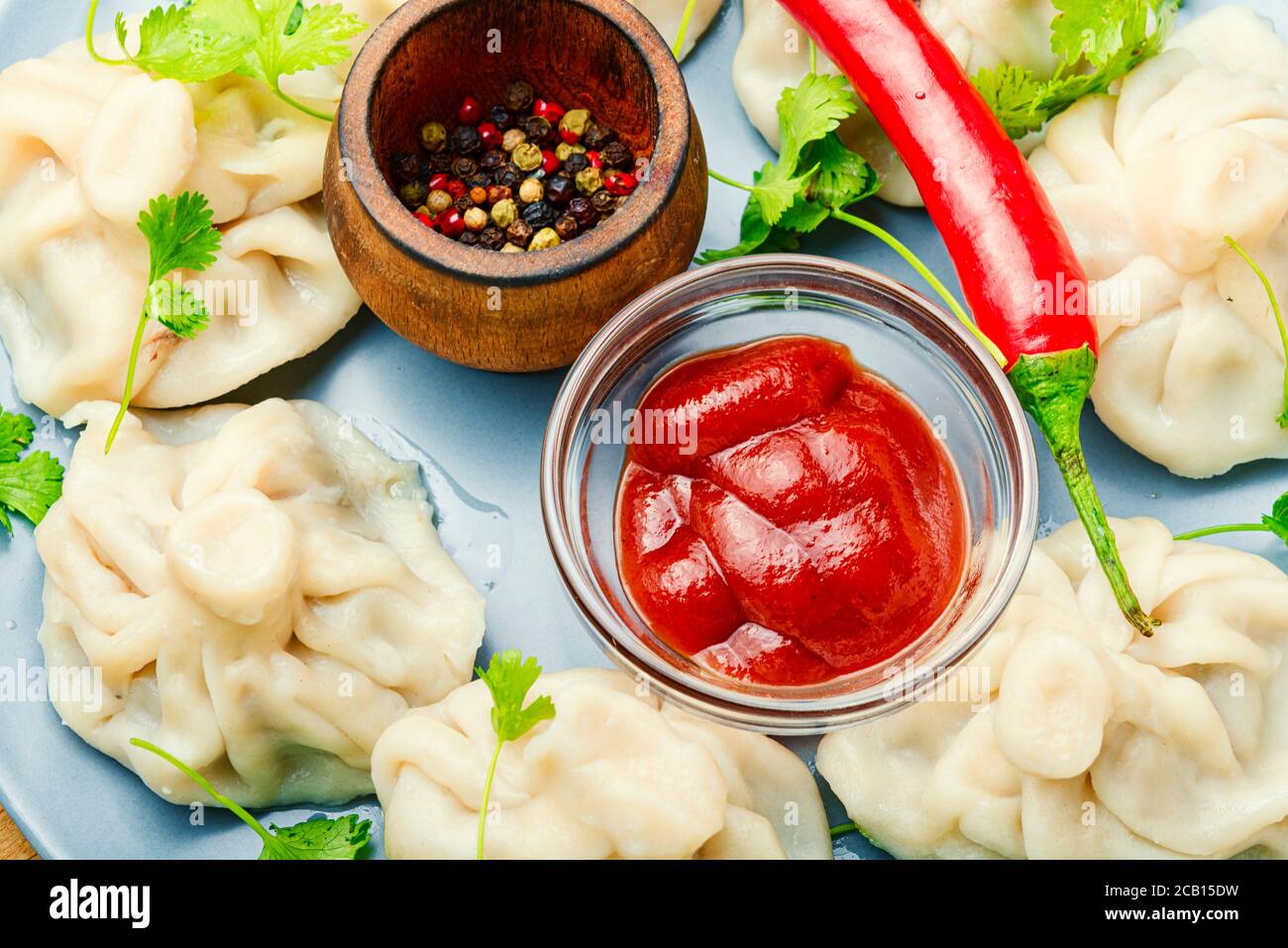 Georgian dumplings khinkali with meat, greens and tomato sauce Stock ...
