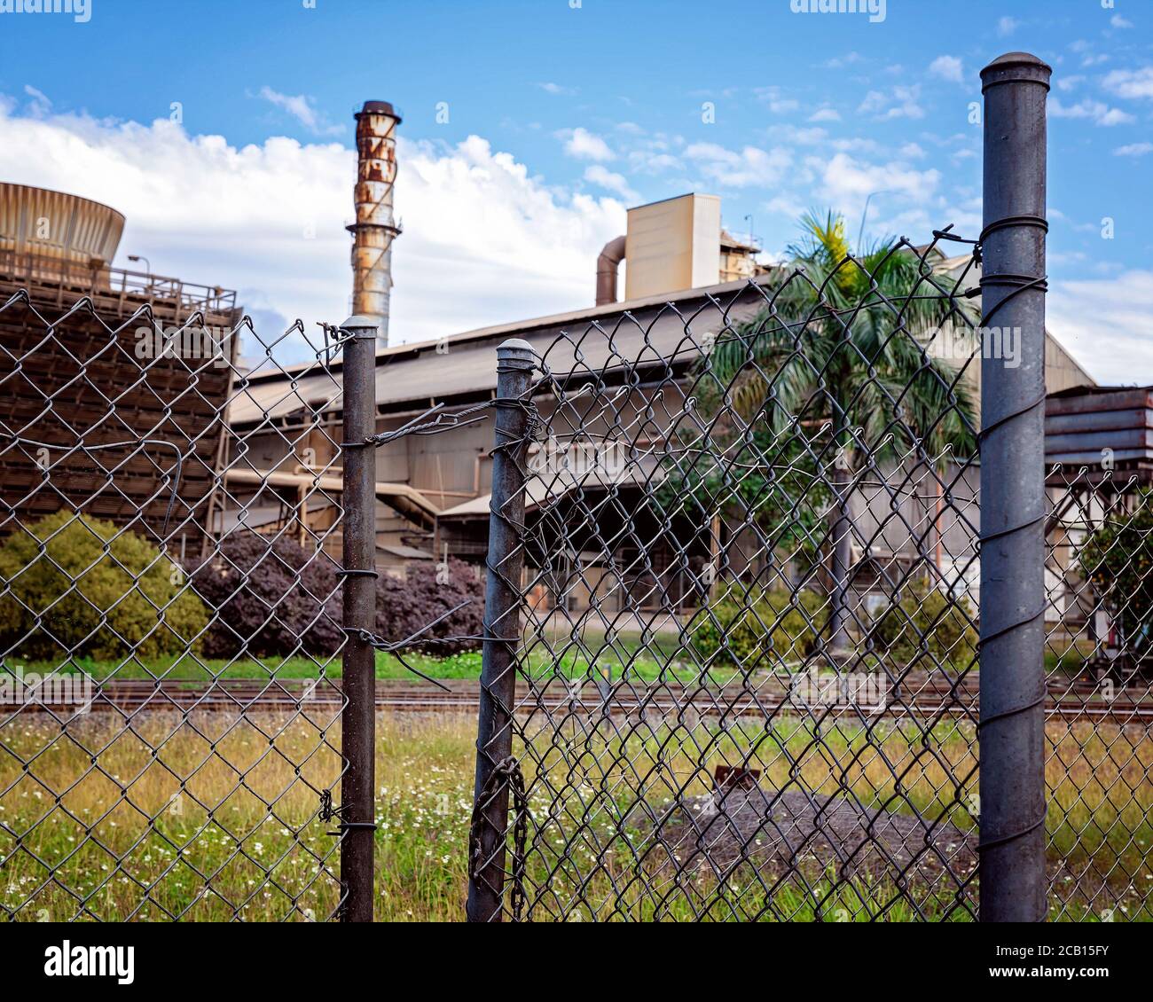 A sugar cane milling factory viewed behind a wire fence Stock Photo - Alamy