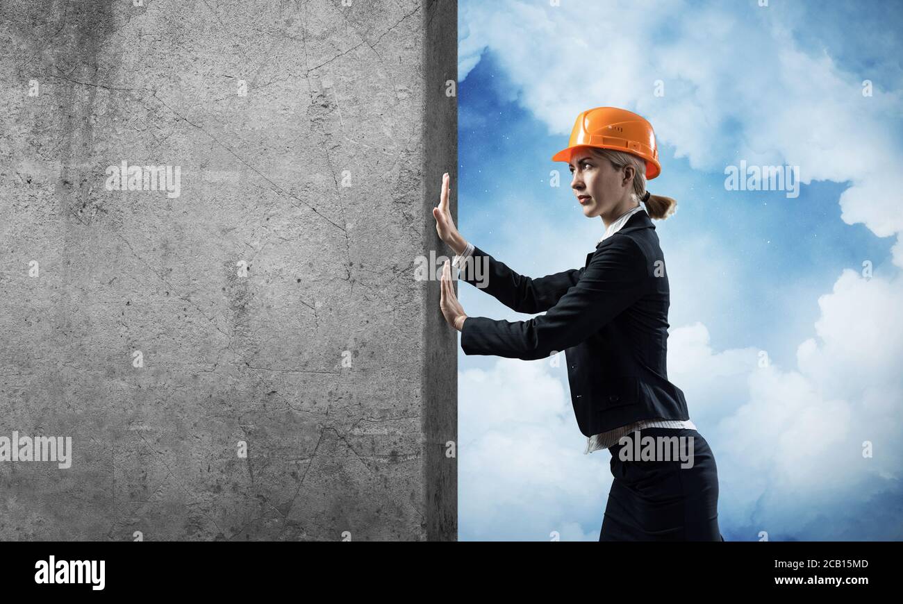 Beautiful woman architect pushing concrete wall Stock Photo - Alamy