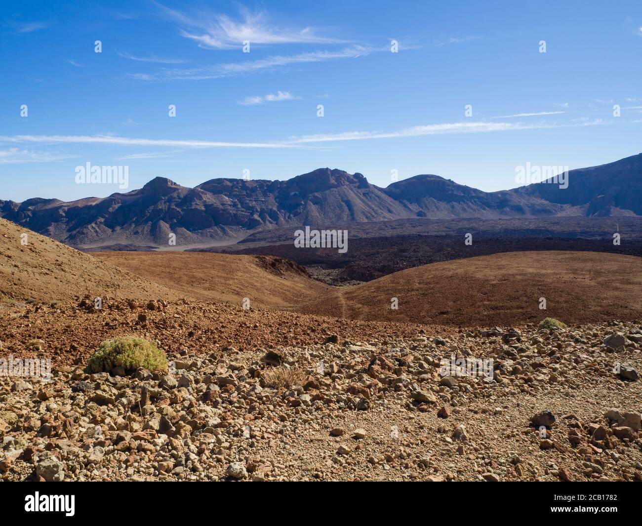 desert volcanic landscape with purple mountains orange sand and dry ...