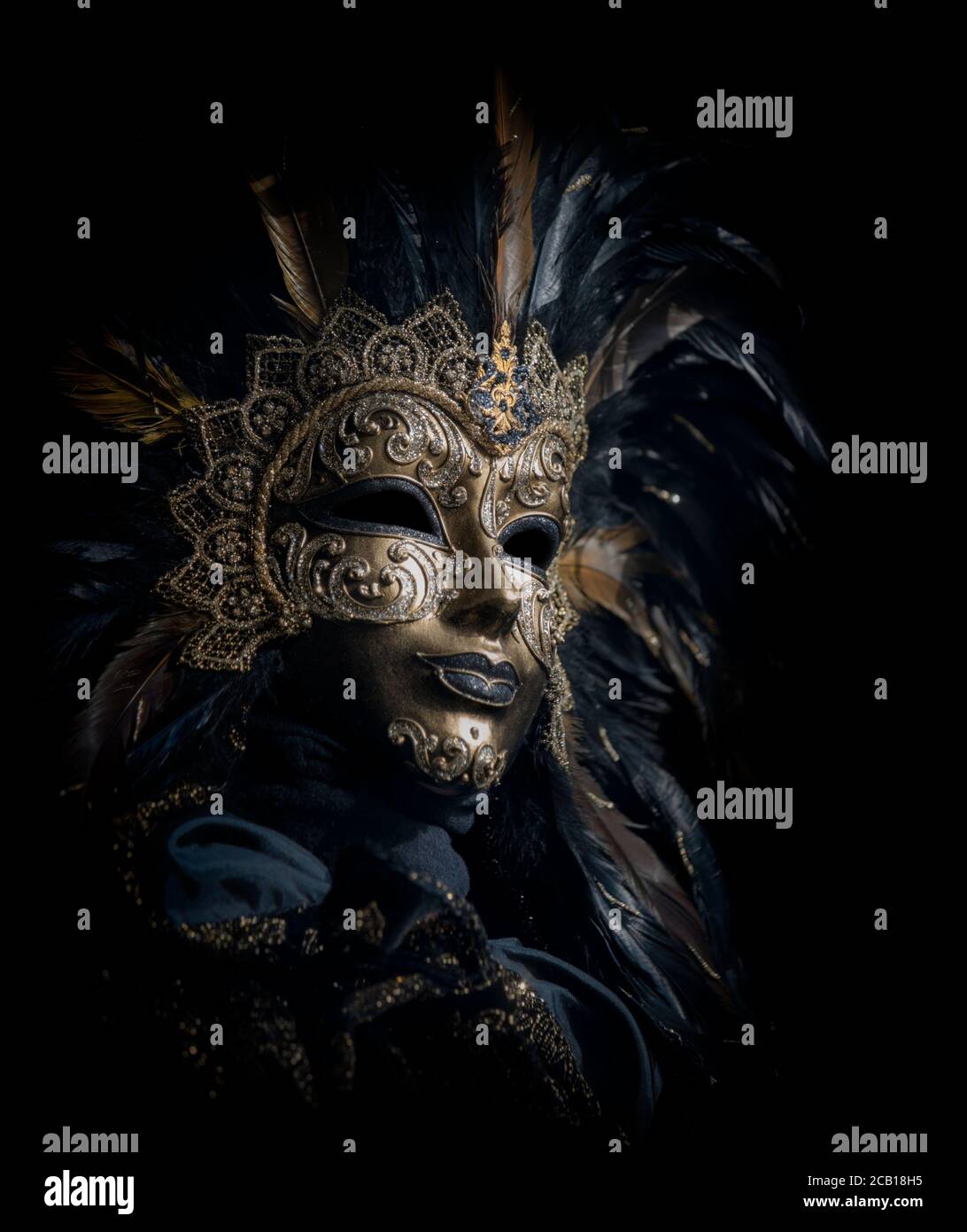 Fancy golden venetian mask isolated on black background with plume ...