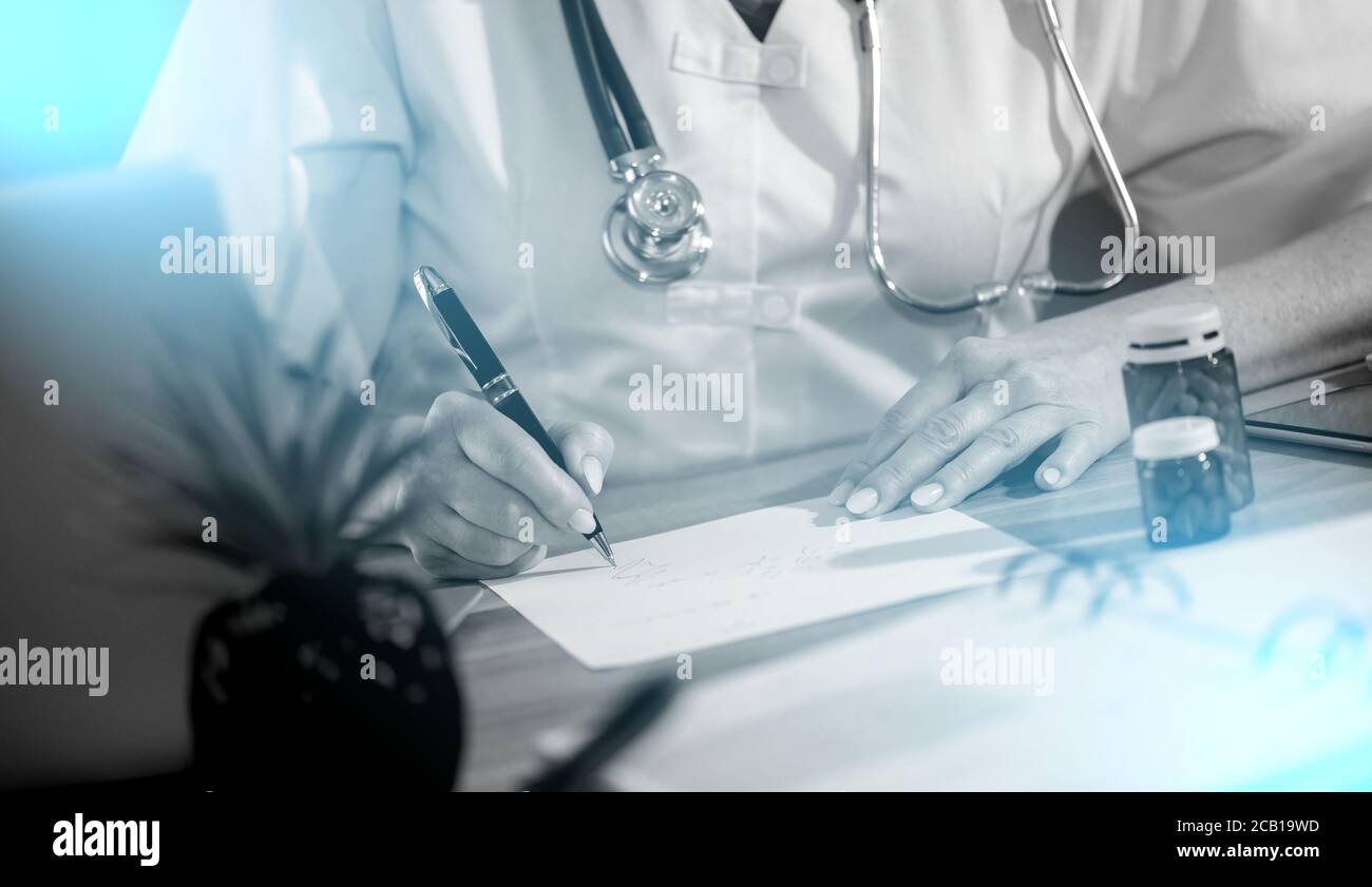 Female doctor writing prescription in medical office; light effect ...