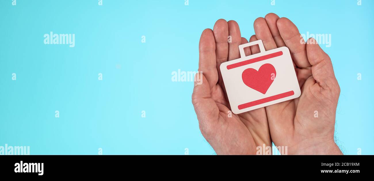 Hands holding a paper medical briefcase on light blue background ...