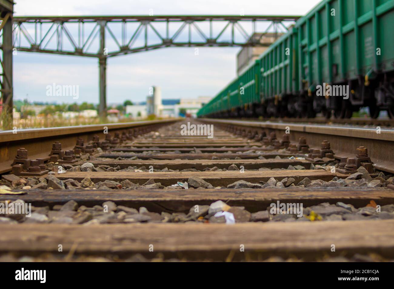 Low angle shot of a railroad and a green train Stock Photo - Alamy